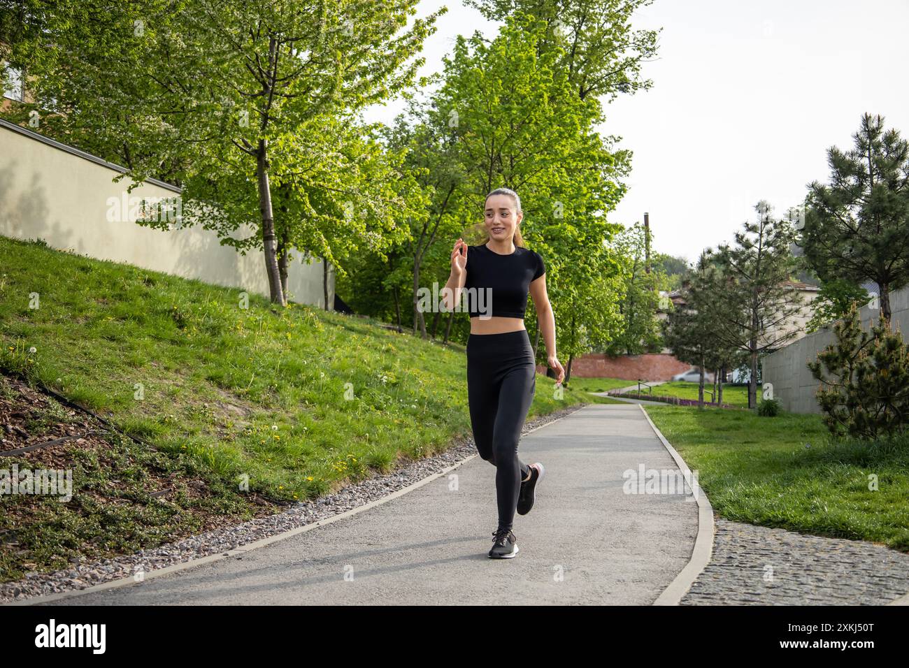 Woman running on asphalt road in summer park active sporty female Stock ...
