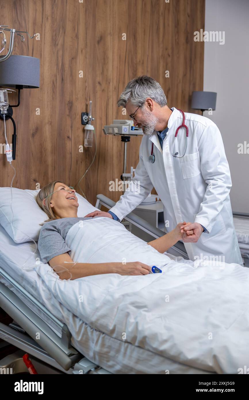 Doctor having an examination of a patient in an intensive therapy unit ...