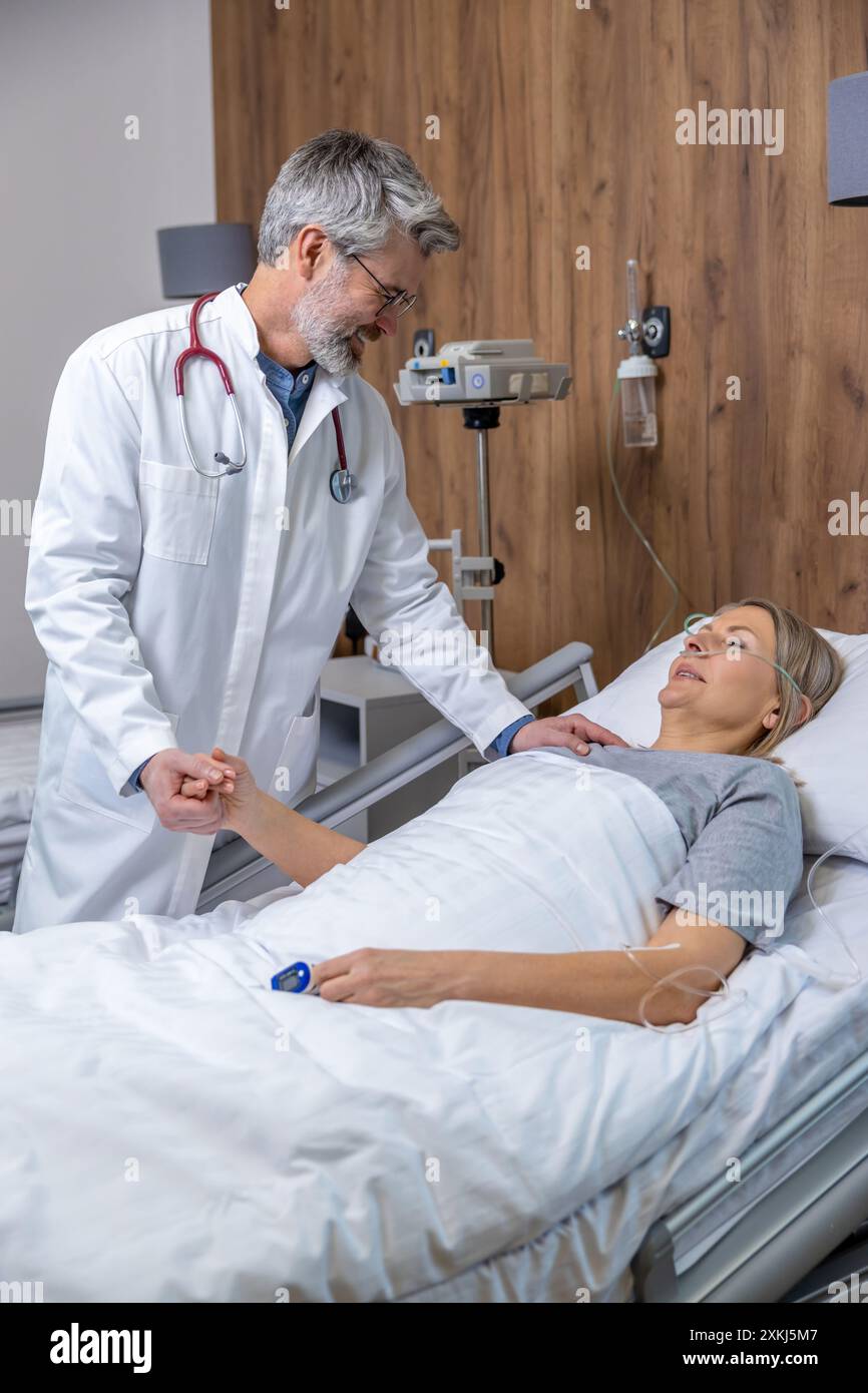 Doctor having an examination of a patient in an intensive therapy unit ...