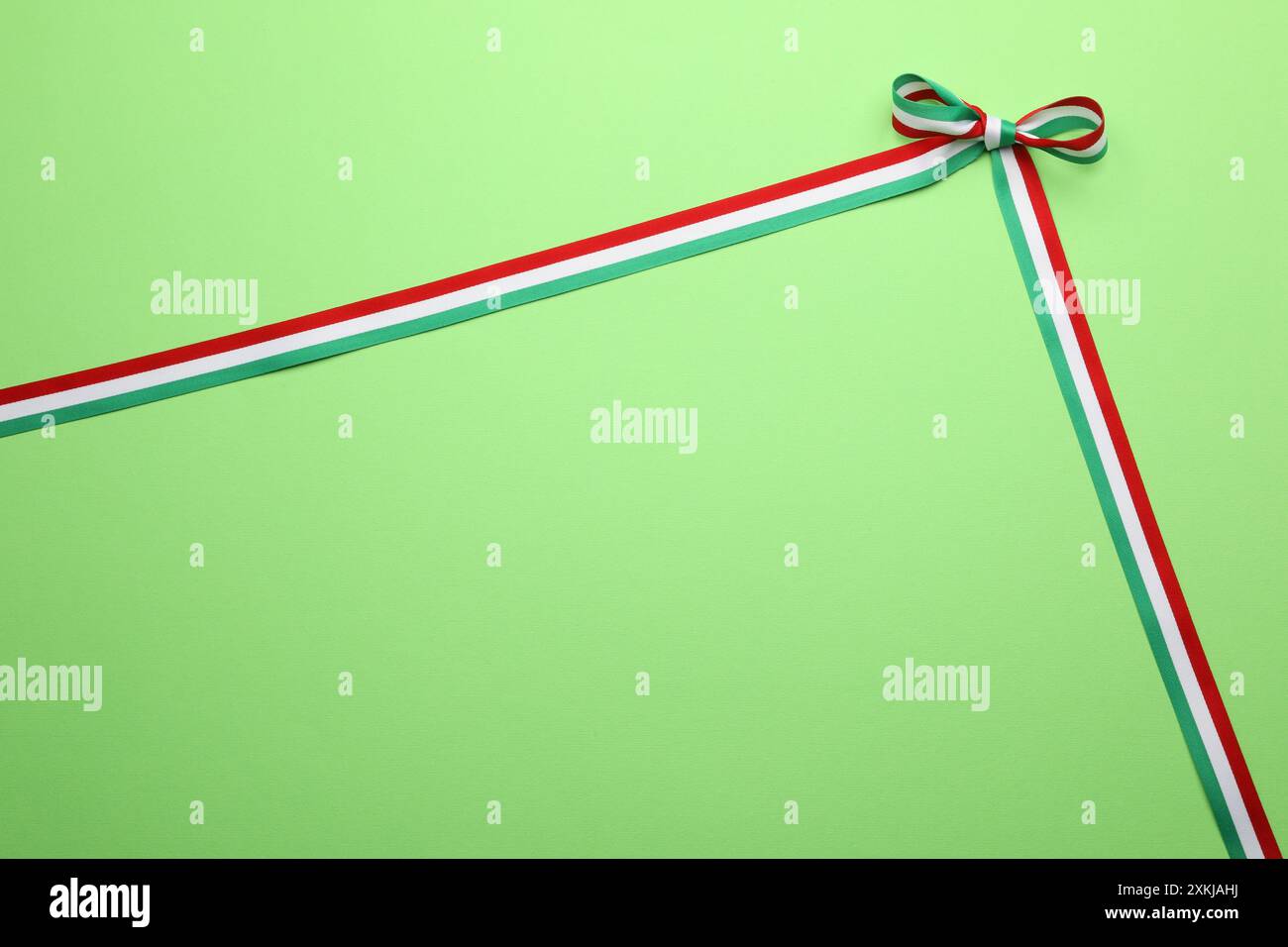 Ribbon with bow in colors of Hungarian flag on green background, top ...