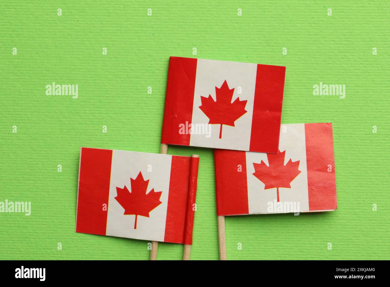Small paper flags of Canada on green background, top view Stock Photo ...