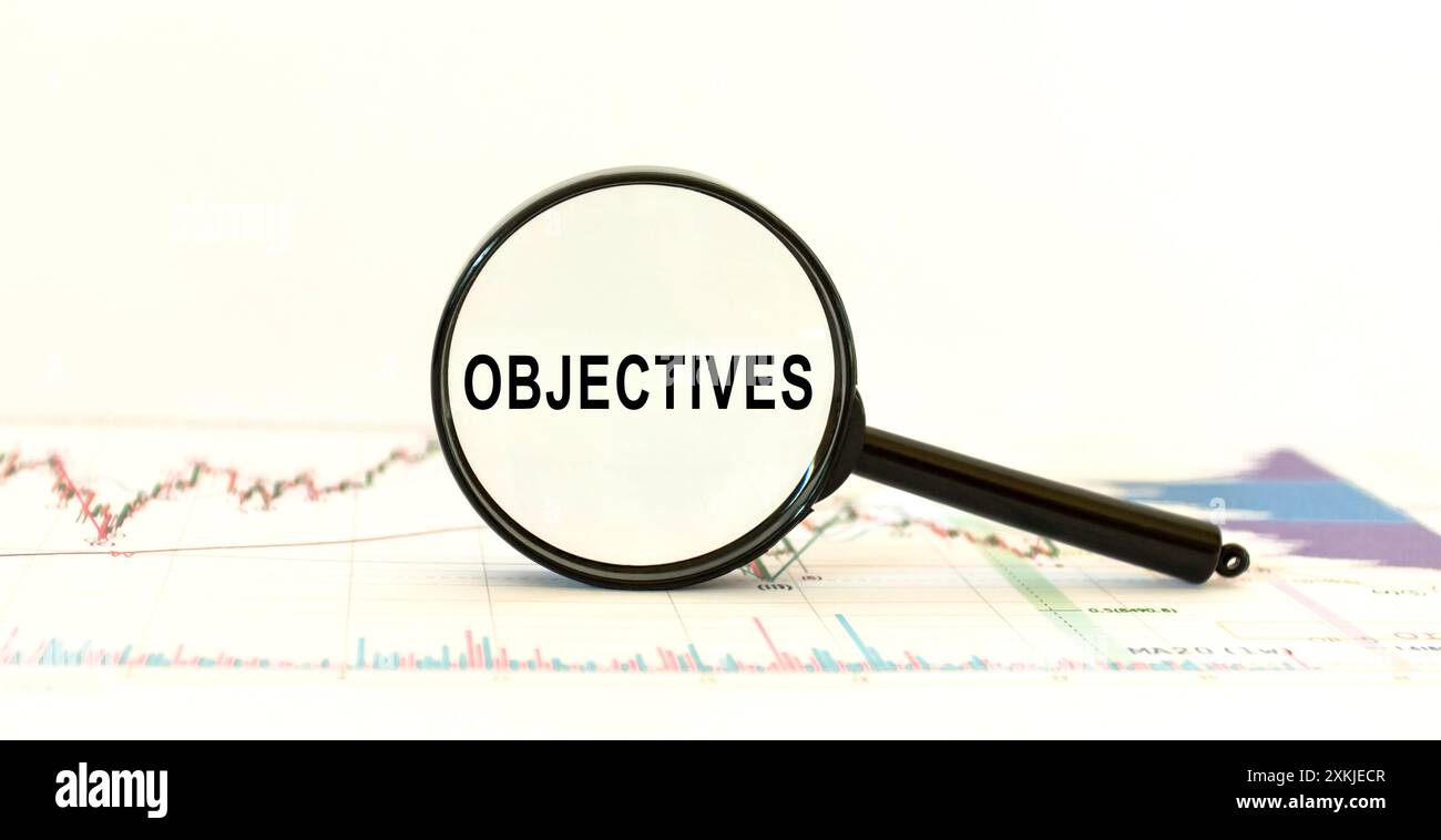 Magnifying Glass with text Objectives on on background with charts ...