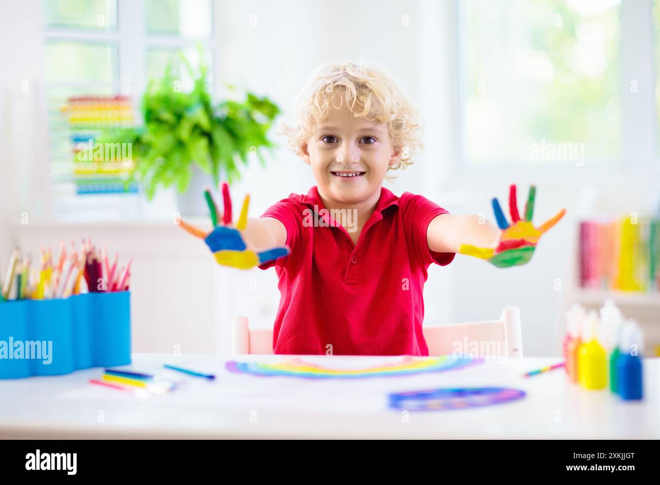 Kids paint. Child painting in white sunny study room. Little boy ...