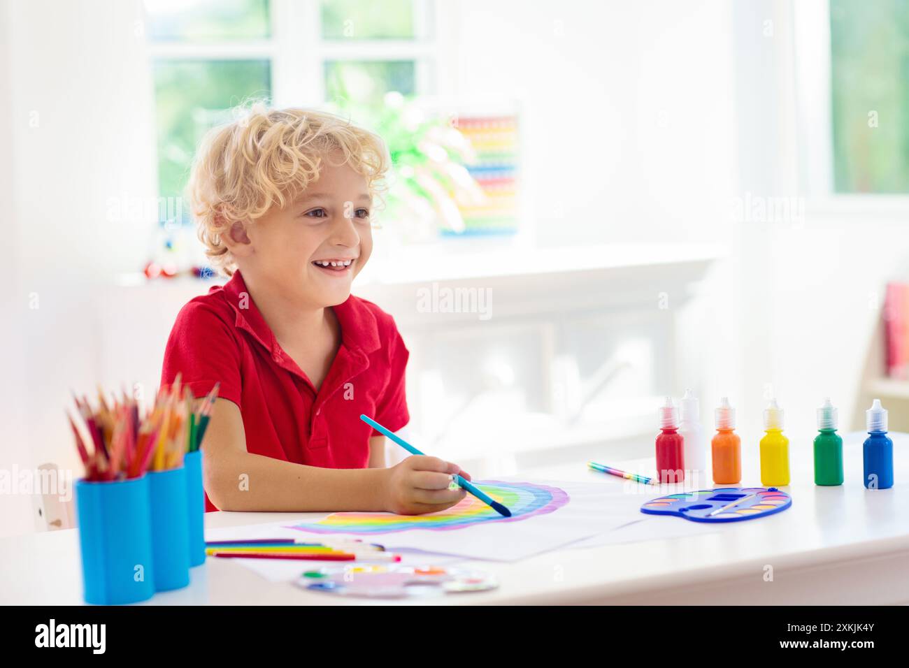 Kids paint. Child painting in white sunny study room. Little boy ...