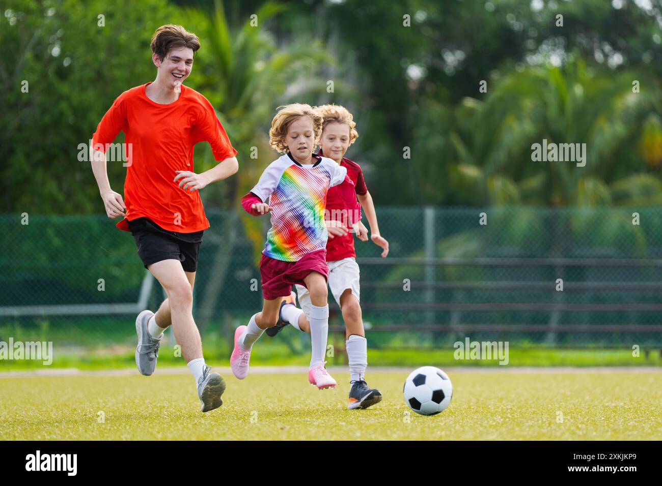 Child playing football. Kids play soccer on outdoor pitch. Little boy ...