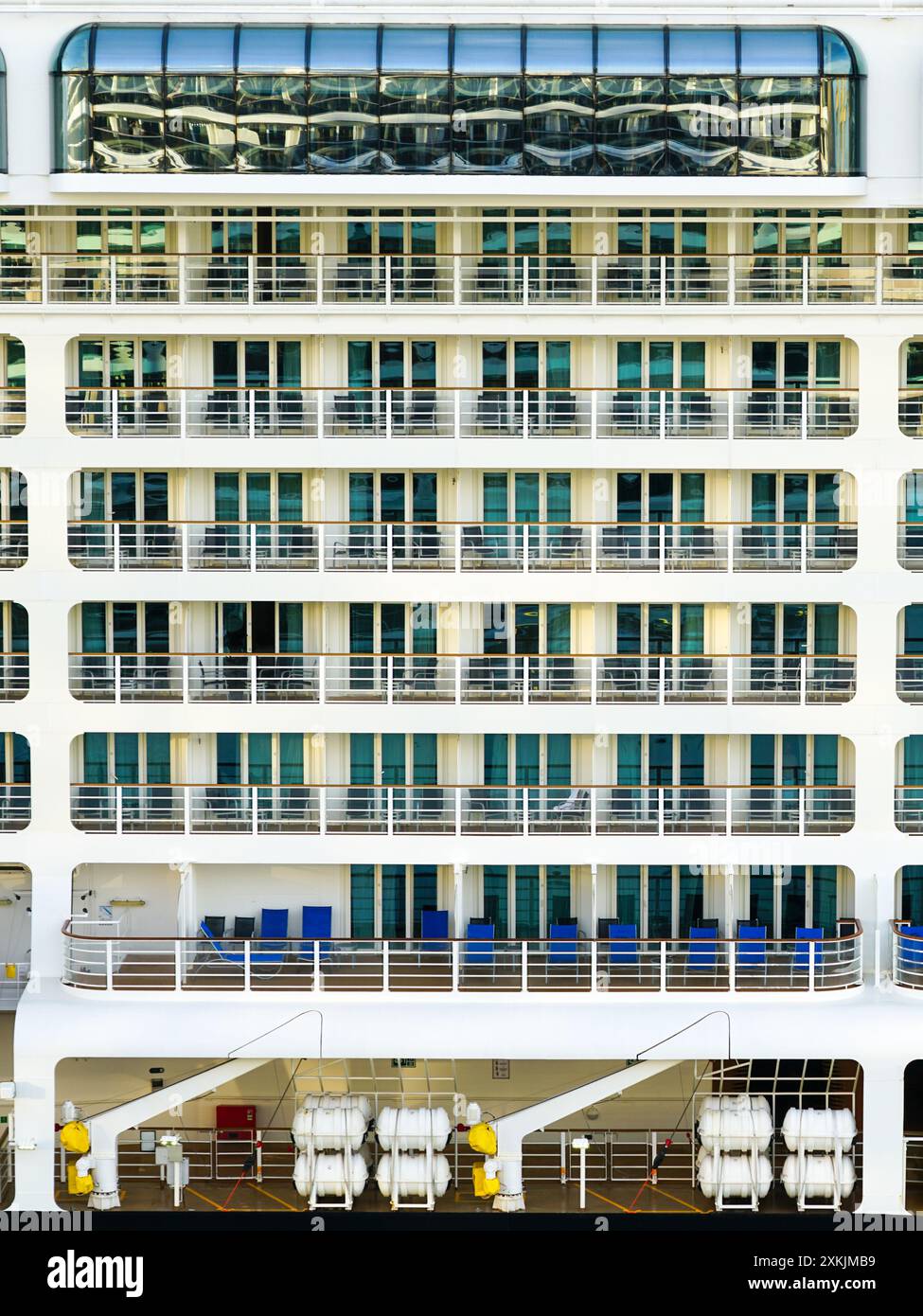 Large multi-story cruise ship side view fragment with multi-deck cabins ...