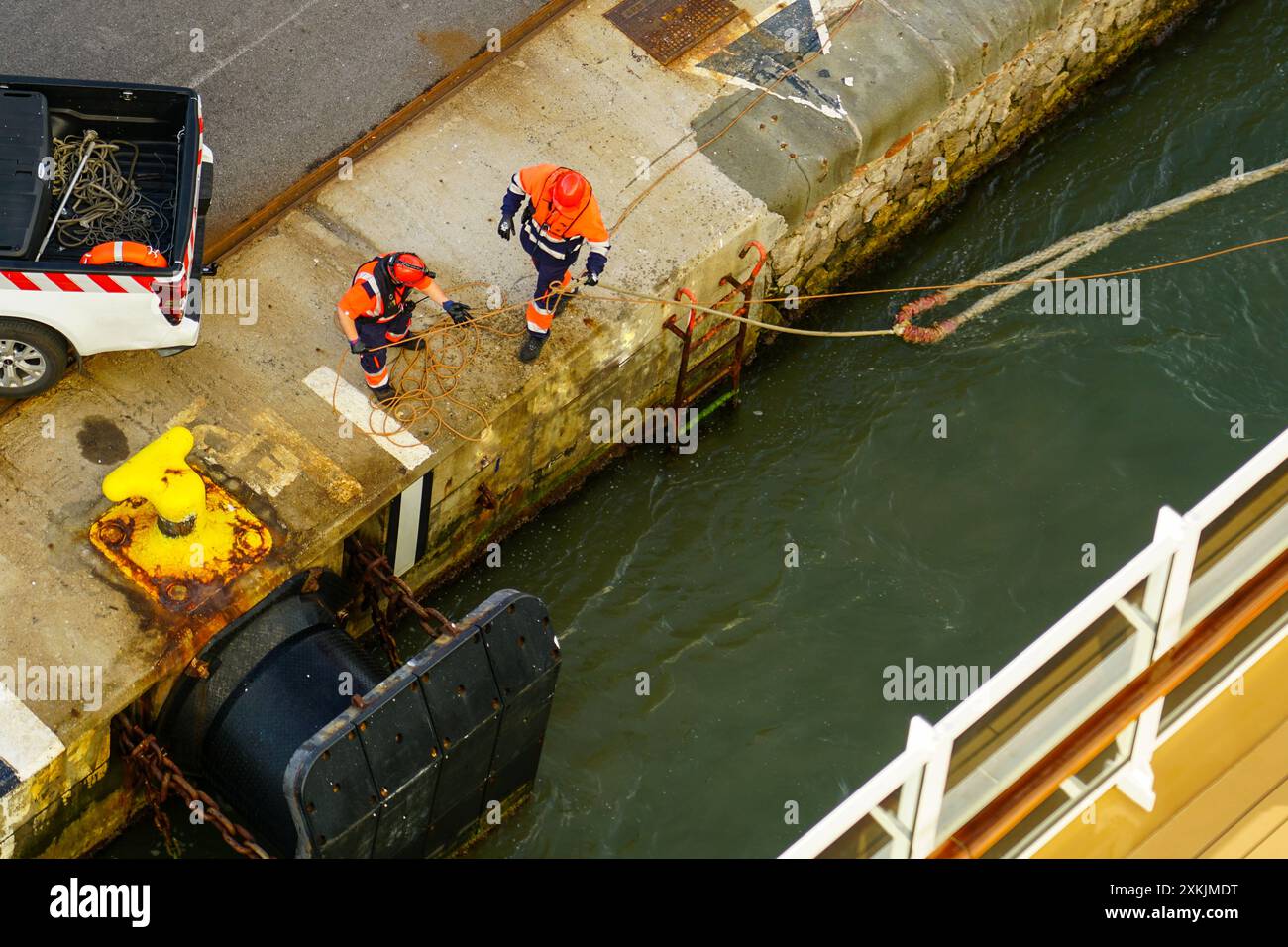 The process of mooring a large cruise ship with a rope at the harbor ...