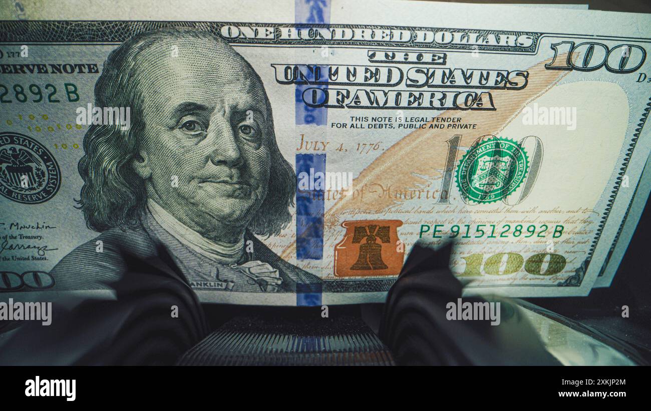 Close up of bill counter machine counting hundred dollar banknotes for ...