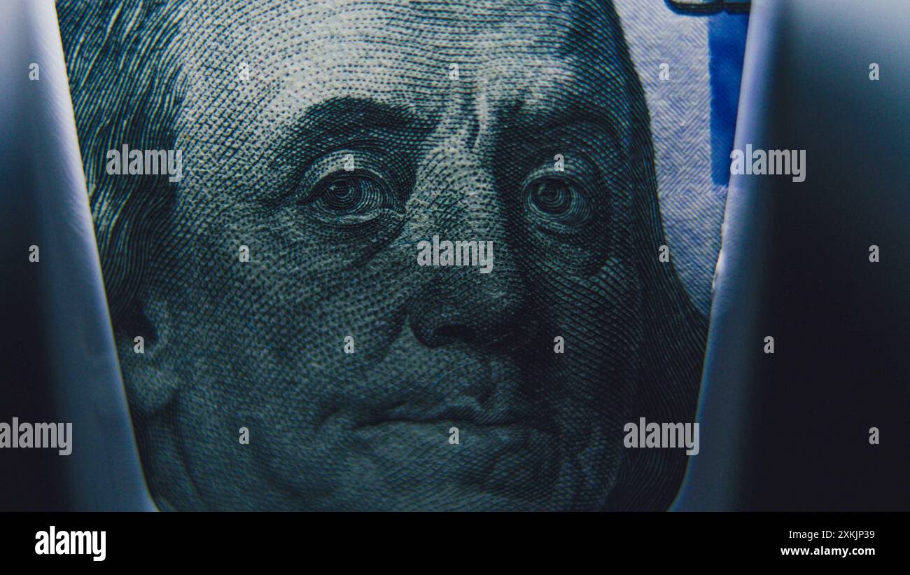 Close up of light flare illuminating hundred dollar banknote with ...