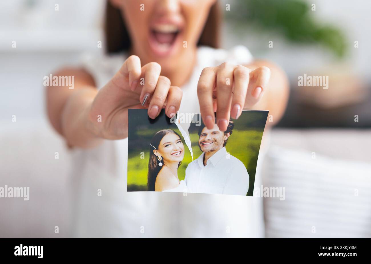 Angry Woman Ripping Photo With Ex-Husband Indoor Stock Photo - Alamy