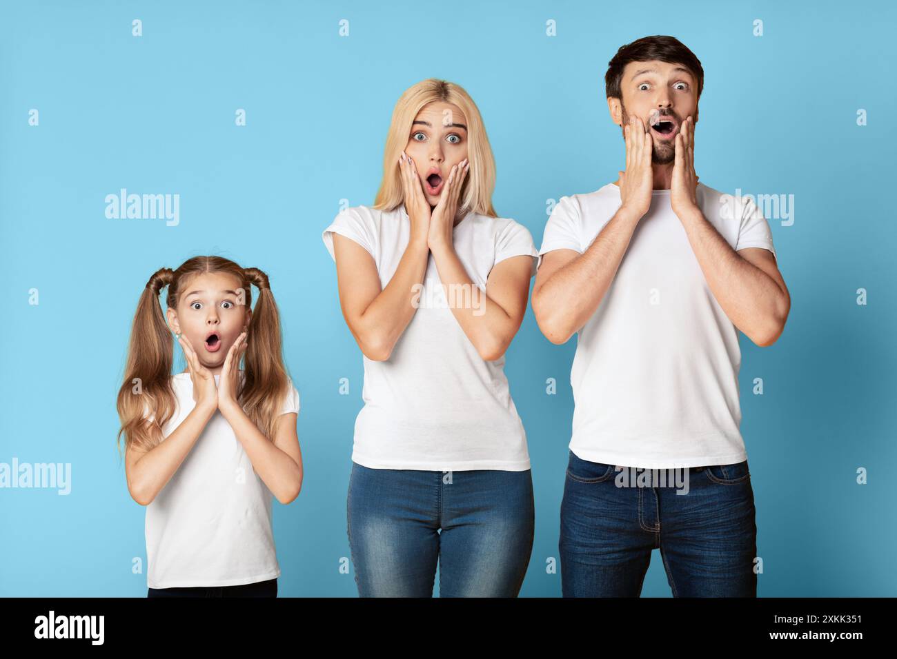 Shocked Family Posing Against Blue Studio Background Stock Photo - Alamy