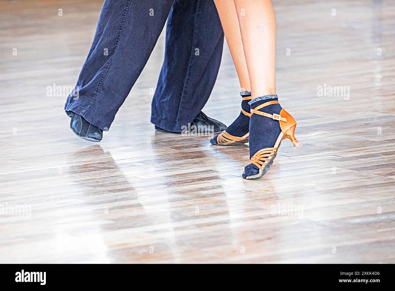 dancer practices in worn out leather shoes on the floor with a teacher ...