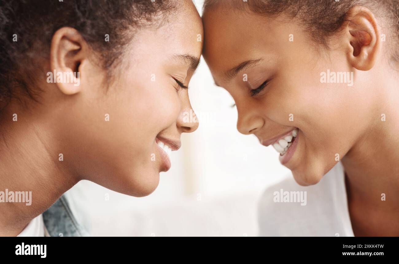 Two sisters with eyes closed touching each other with foreheads Stock ...