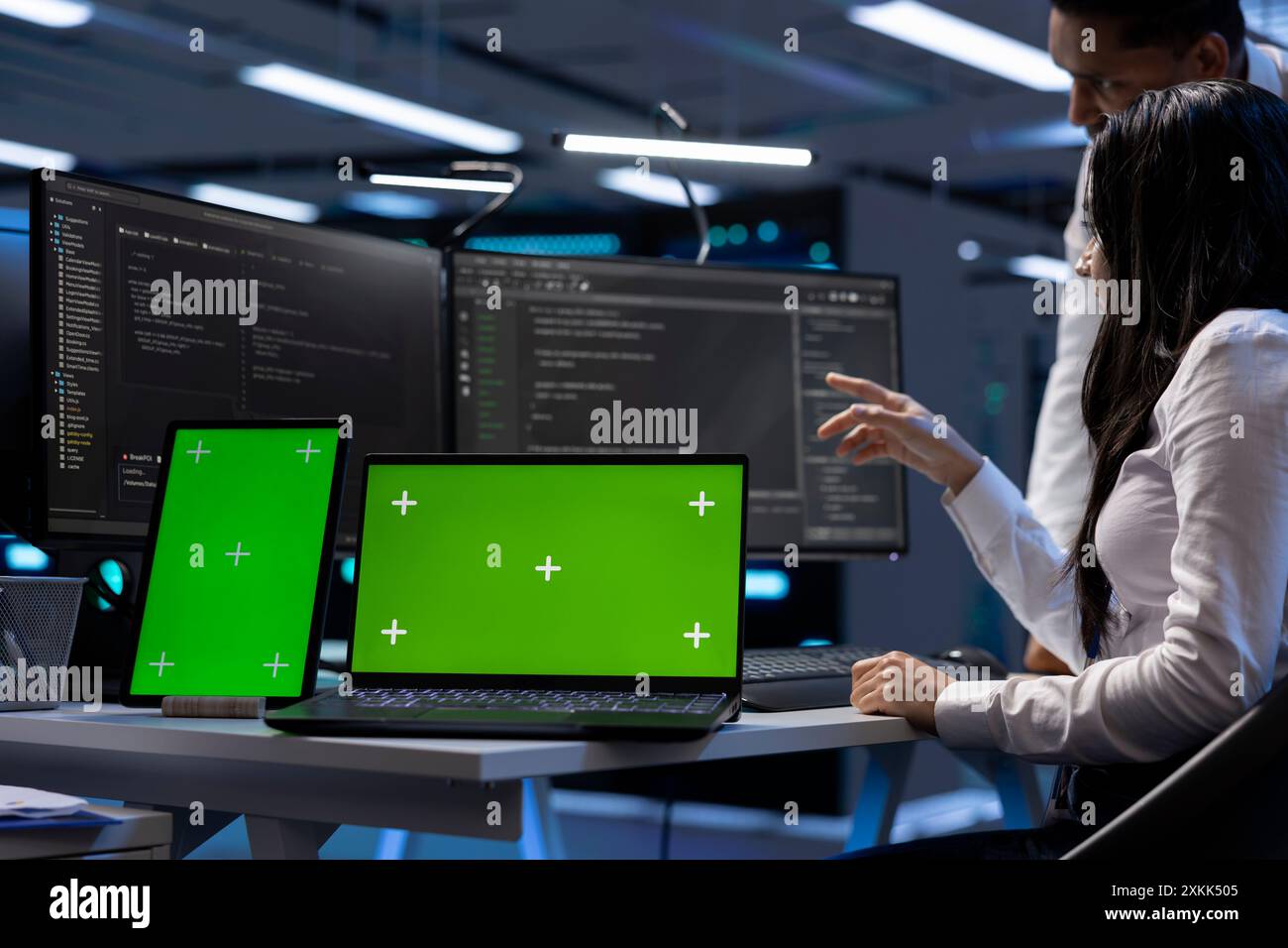 Engineers In Data Center Using Mockup Tablet And Laptop To Check For Server Issues Arising Due