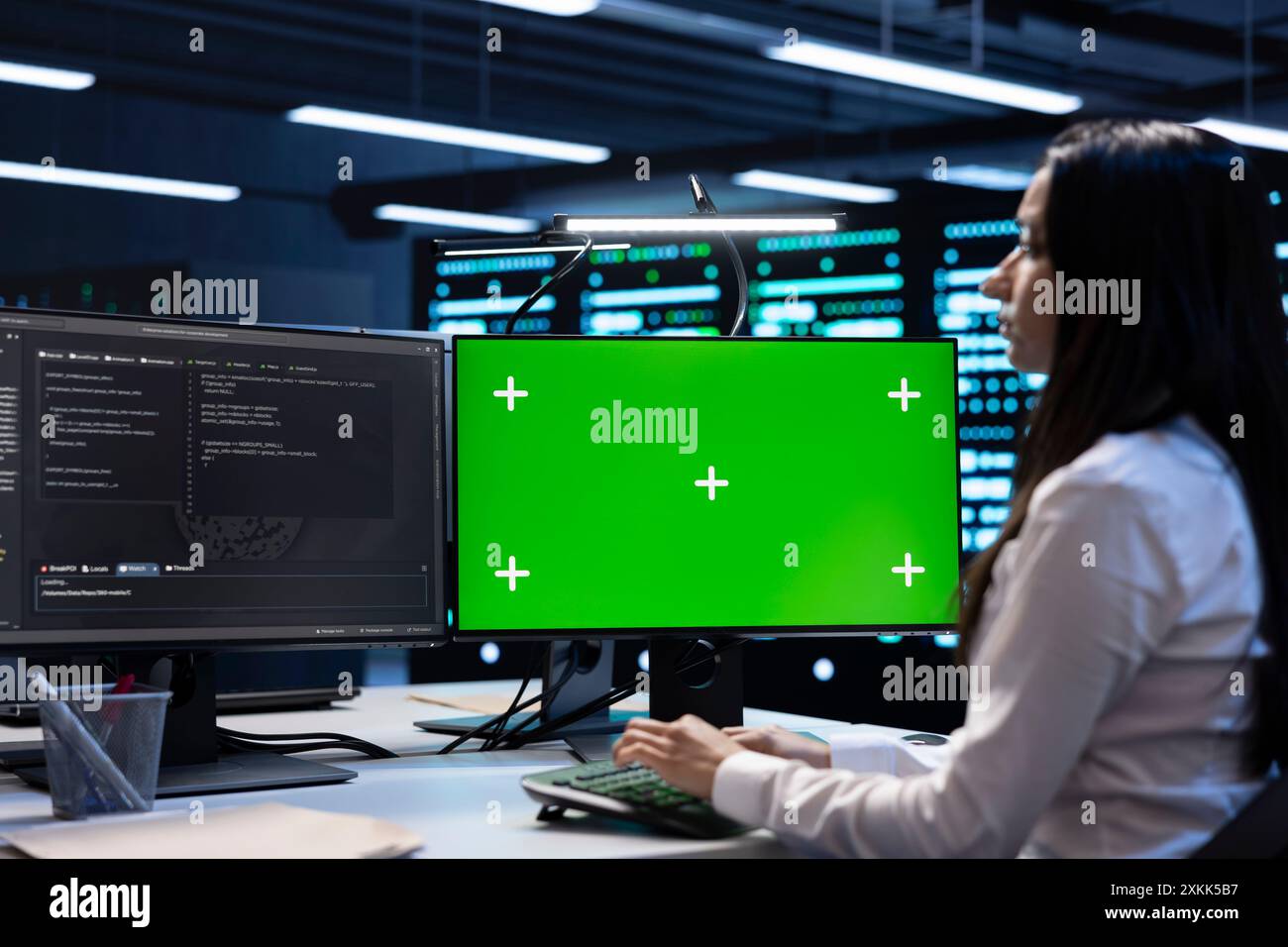 Engineer in server hub using green screen PC to repair equipment ...