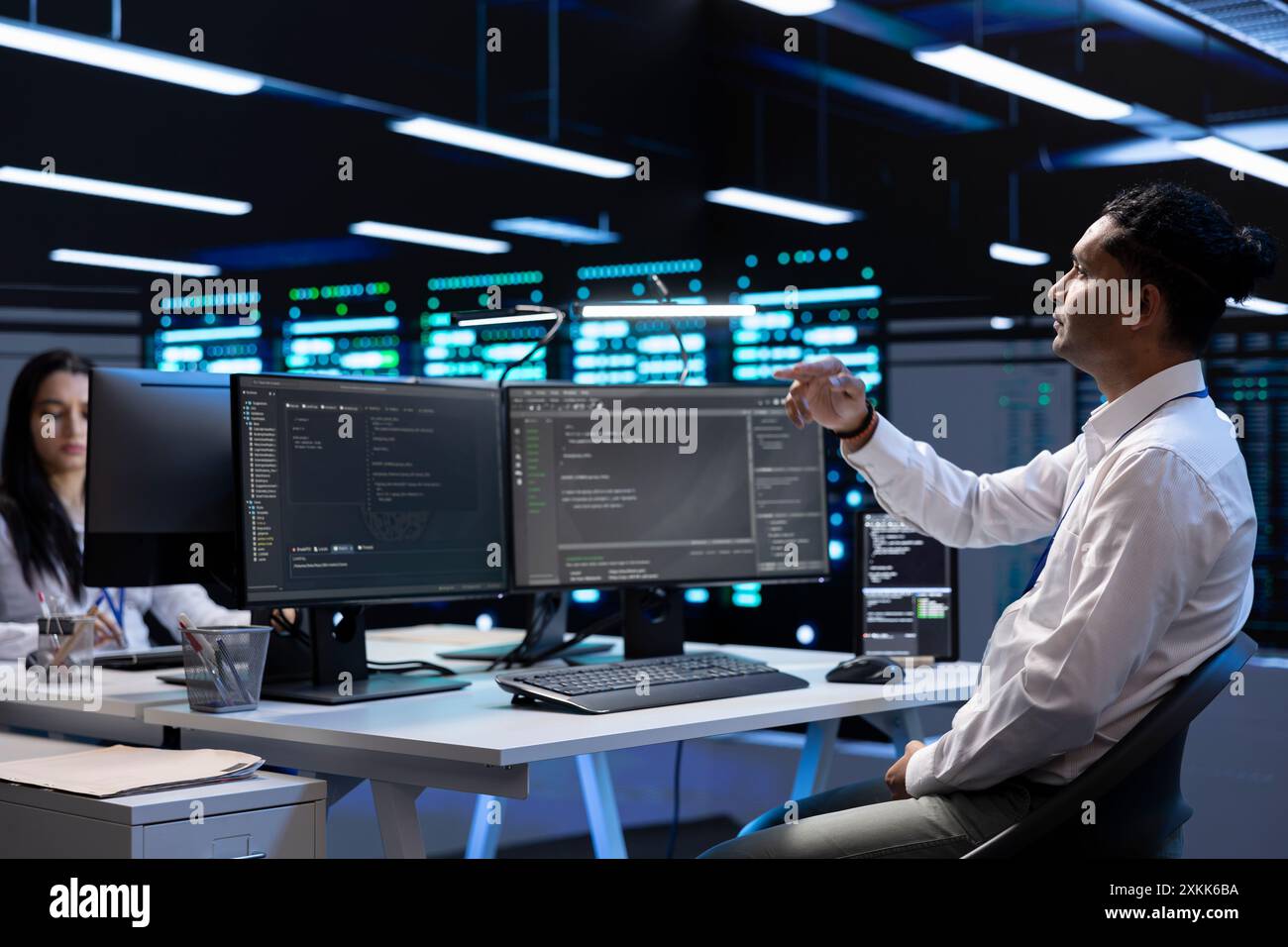 System administrator looking at holograms in data center, monitoring equipment. IT staff member ...