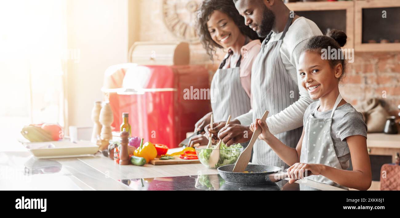 Smiling girl helping parents cooking dinner in kitchen Stock Photo - Alamy