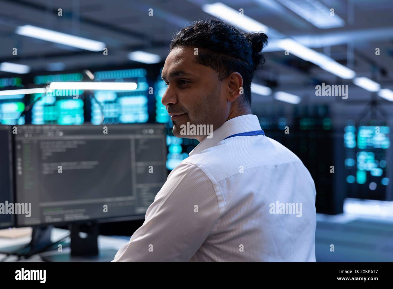 Computer scientist in data center using diagnostic tools and system monitoring software to ...