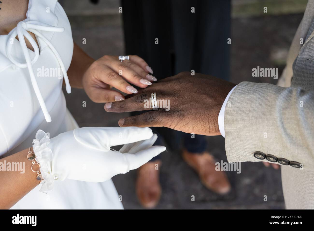 Newly married bride places wedding ring on the black finger of her ...