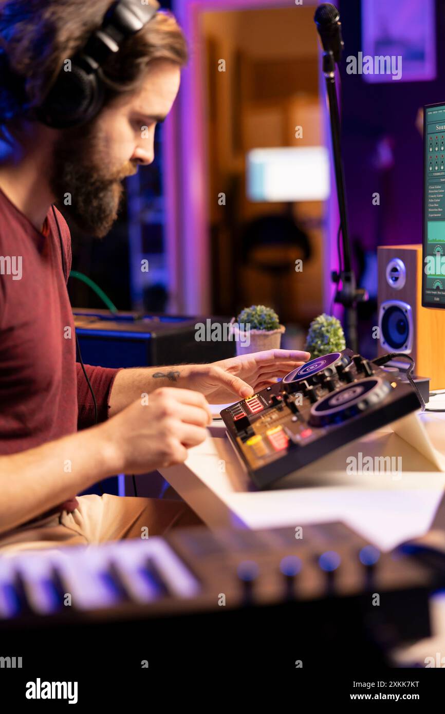 Music engineer editing his soundtracks on mixing console, using control ...