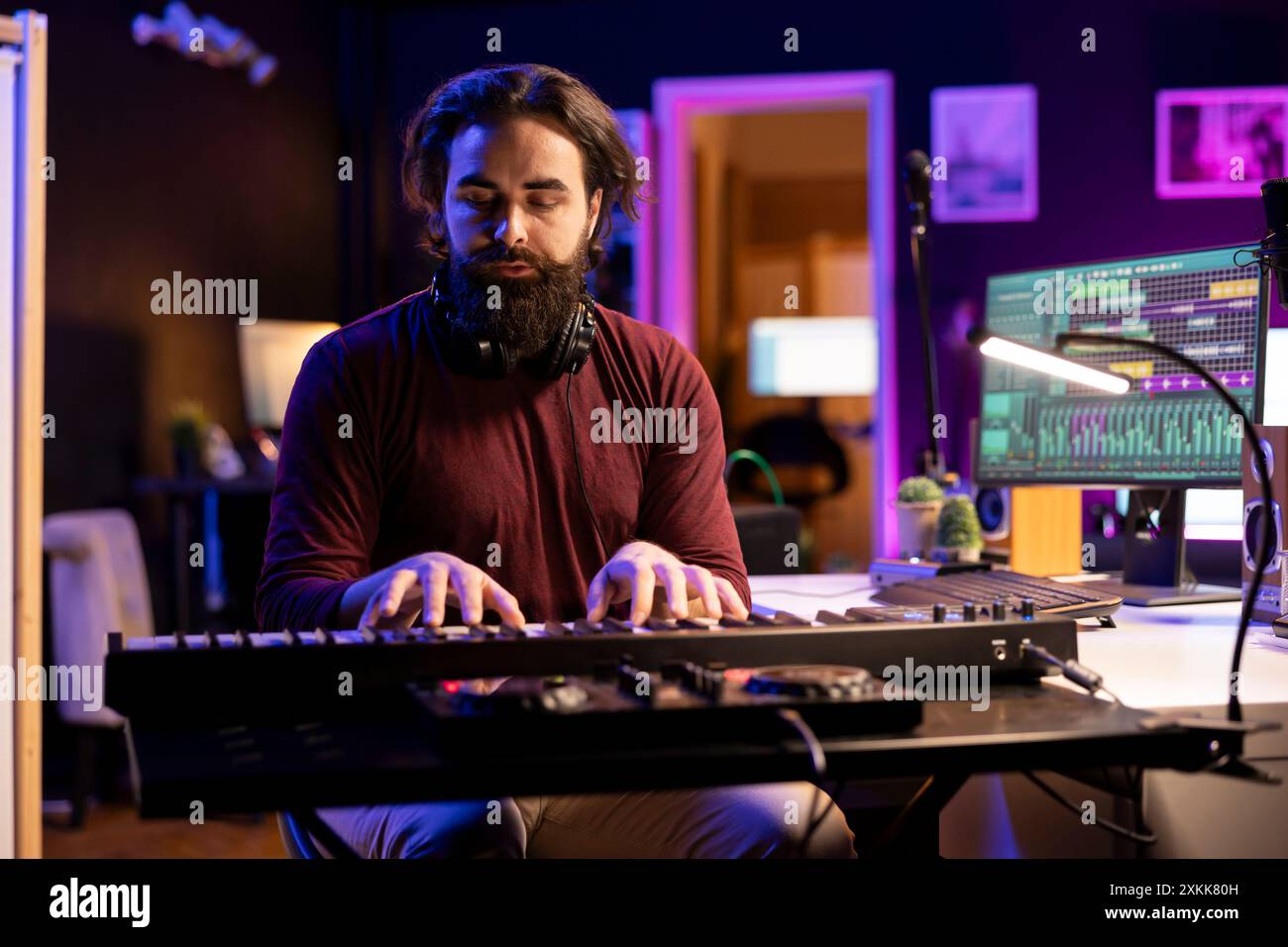 Skilled producer creating new music on piano midi controller, working ...