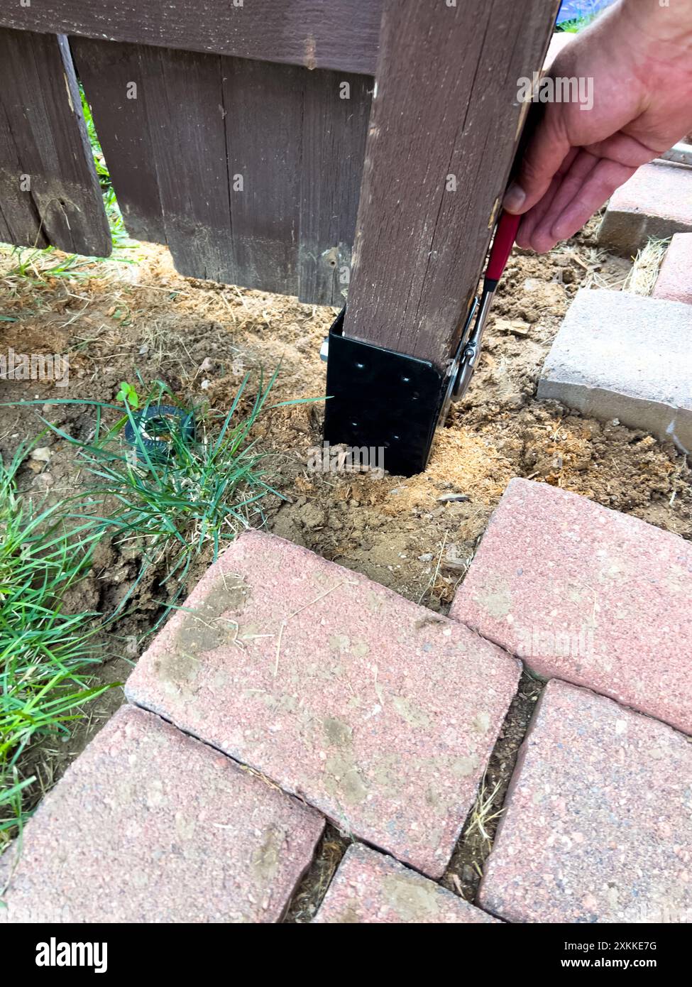 Repairing a Fence Post with Tools and Brick Pavers Stock Photo - Alamy