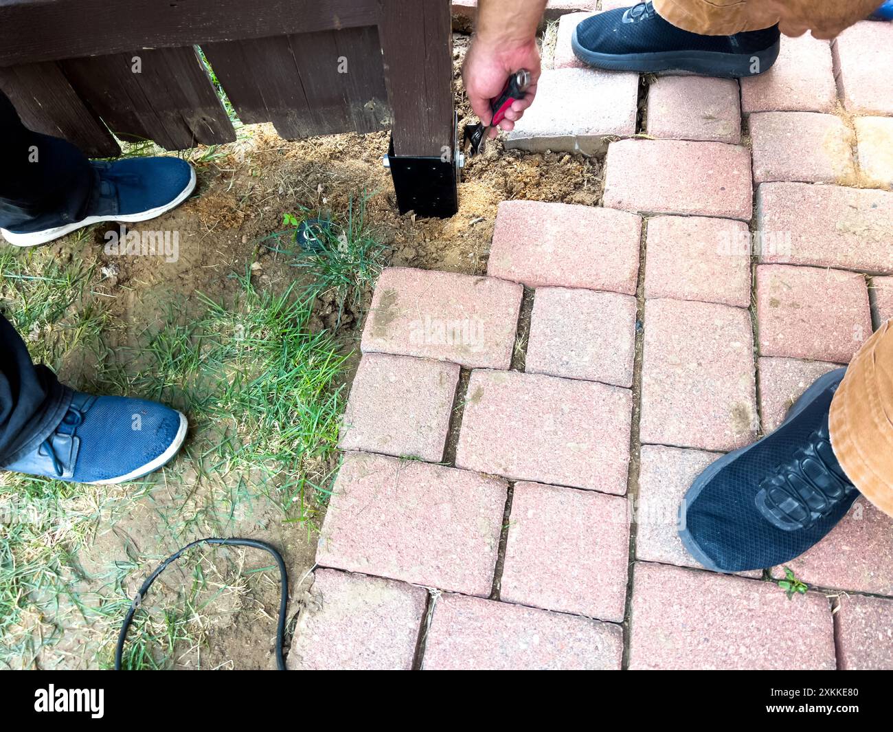 Repairing a Fence Post with Tools and Brick Pavers Stock Photo - Alamy
