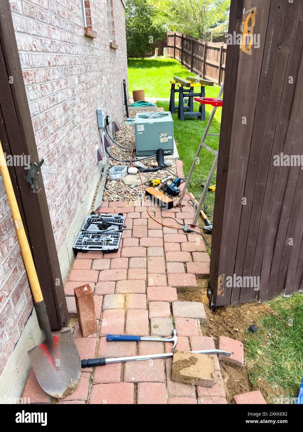 Repairing a Fence Post with Tools and Brick Pavers Stock Photo - Alamy