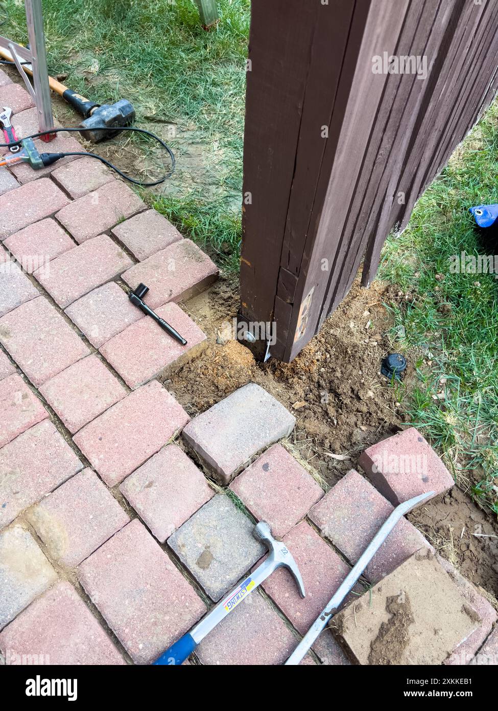 Repairing a Fence Post with Tools and Brick Pavers Stock Photo - Alamy