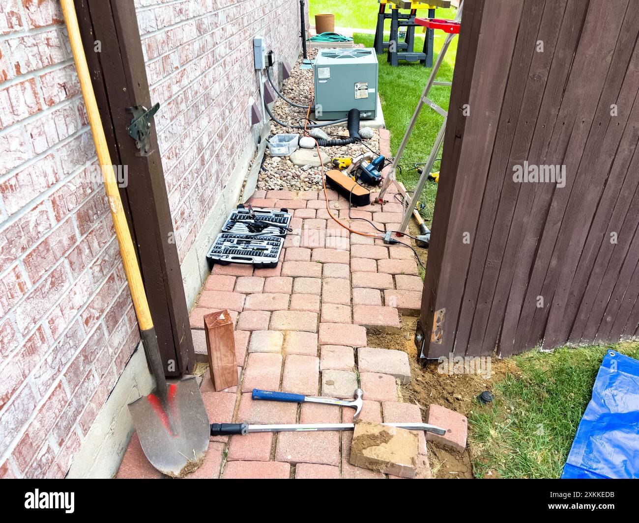 Repairing a Fence Post with Tools and Brick Pavers Stock Photo - Alamy