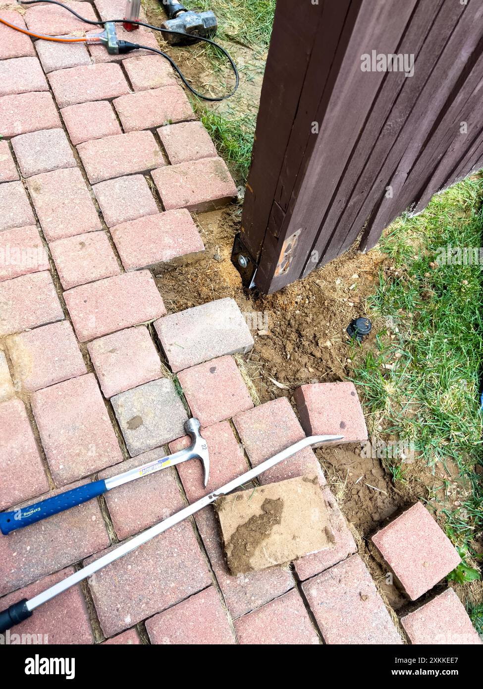 Repairing a Fence Post with Tools and Brick Pavers Stock Photo - Alamy