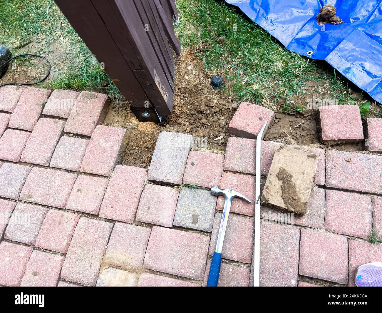 Repairing a Fence Post with Tools and Brick Pavers Stock Photo - Alamy