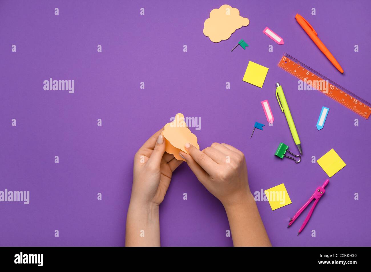 Female hands holding sticky note on purple background Stock Photo - Alamy