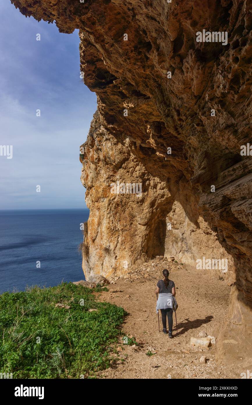 Hiker standing in cave at rocky coastline of Nature Park of Monte ...