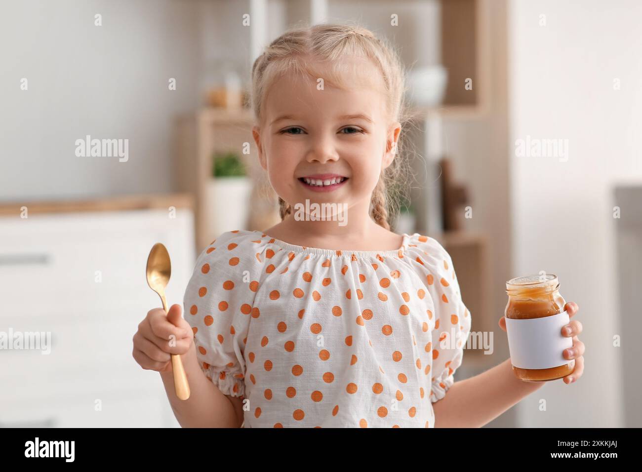 Happy little girl with spoon and jar of jam at home Stock Photo - Alamy
