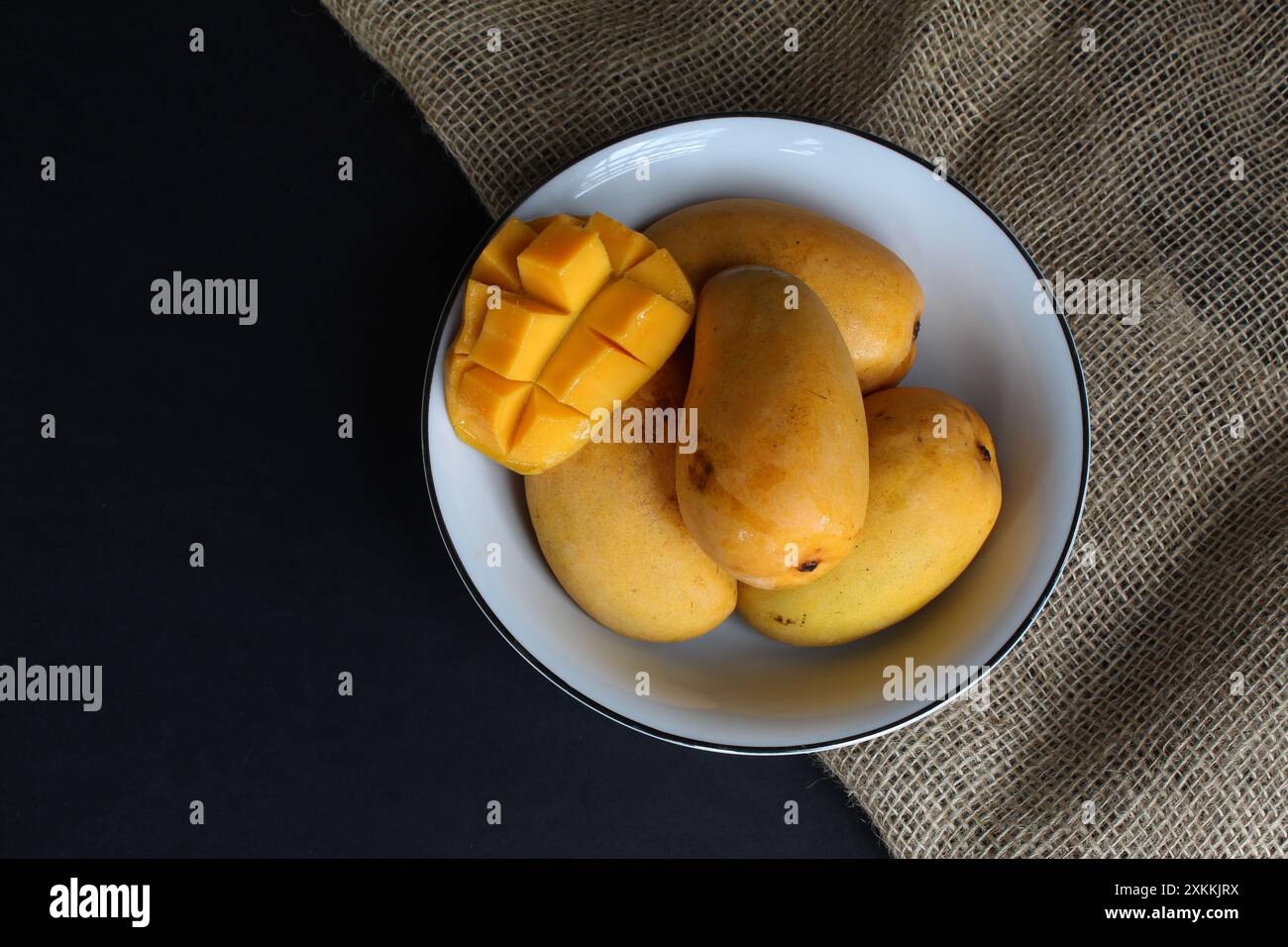 Bowl of mangoes on dark background Stock Photo - Alamy