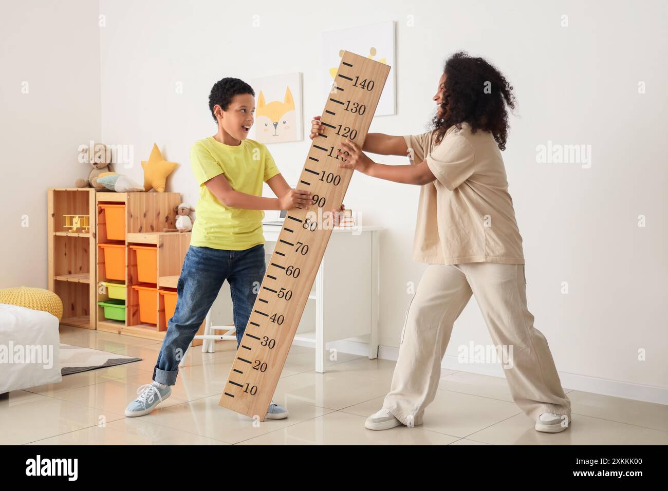 Little African-American children taking stadiometer from each other at ...