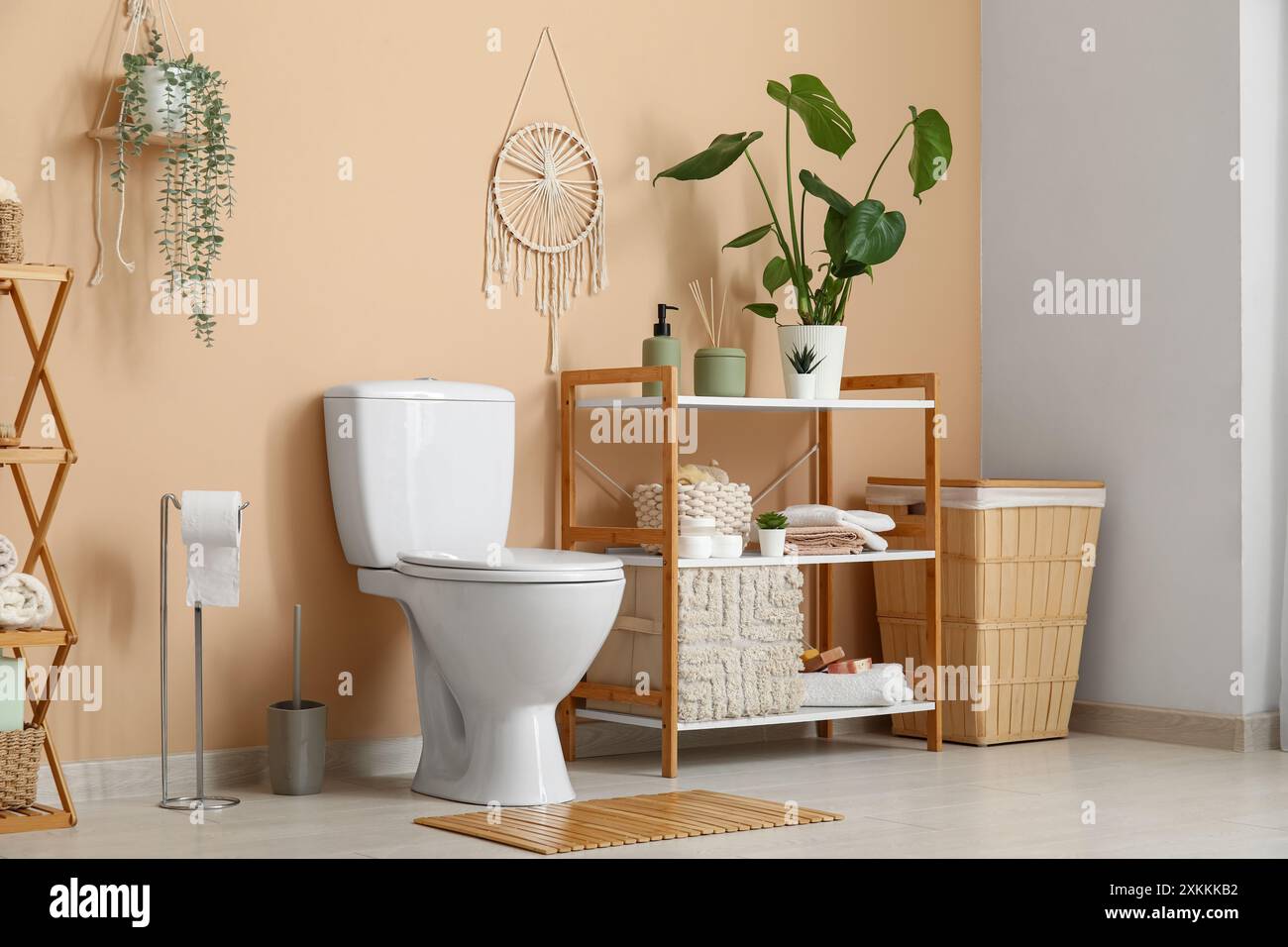 Toilet bowl and shelving units near beige wall in restroom Stock Photo ...