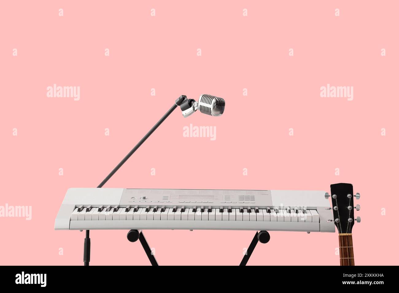 Modern synthesizer, guitar and microphone on pink background Stock ...
