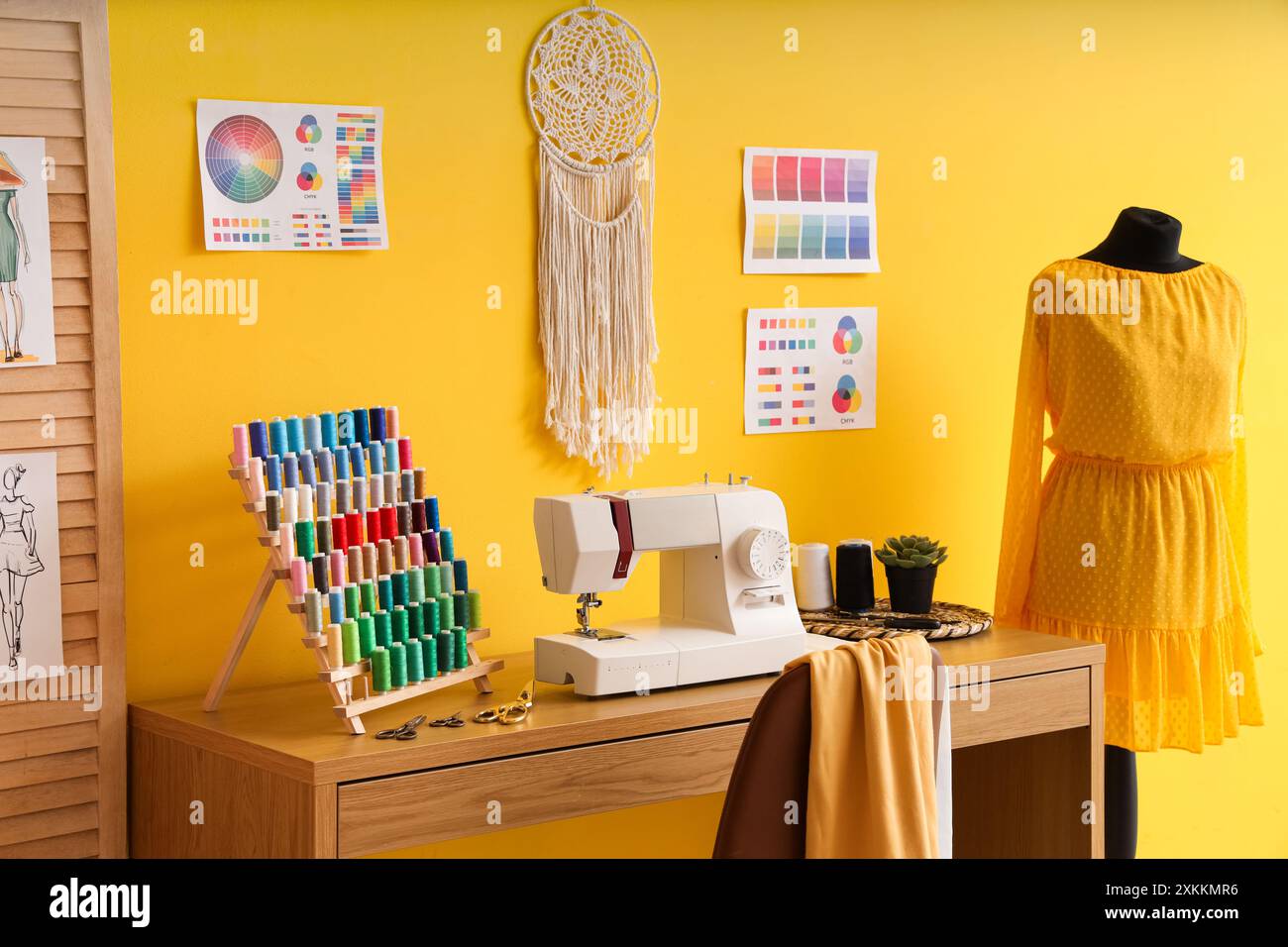 Tailor's workplace with sewing machine, thread spools and color ...