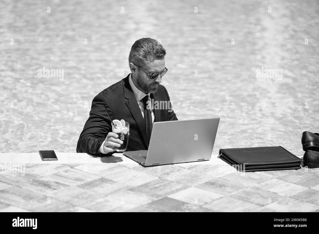 photo of busy business man working remote in summer pool. business man ...