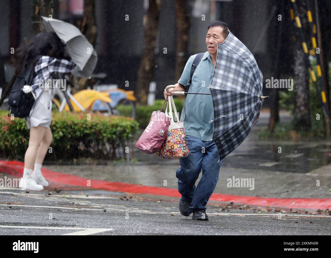 People walk in the rain as Typhoon Gaemi approaches in Taipei, Taiwan ...