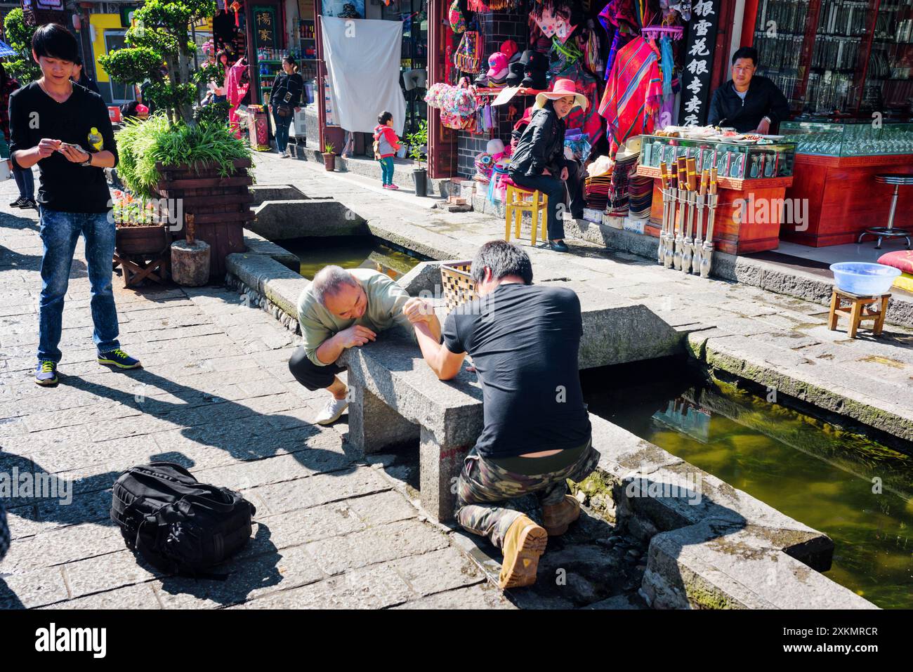 Arm wrestling fight on stone bench in Dali Old Town, China Stock Photo ...