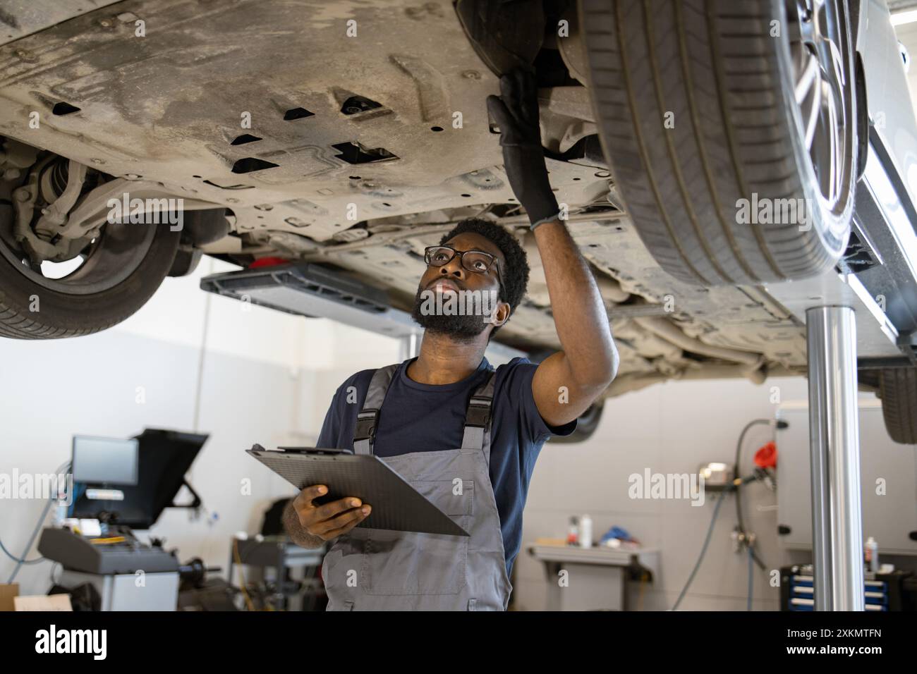 Mechanic inspecting car undercarriage hi-res stock photography and images - Alamy
