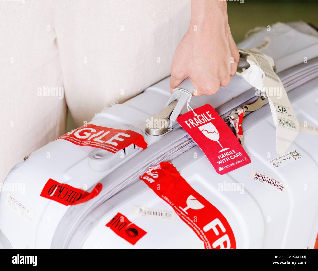 Man holding plastic suitcase with luggage tag (Fragile Stock Photo - Alamy