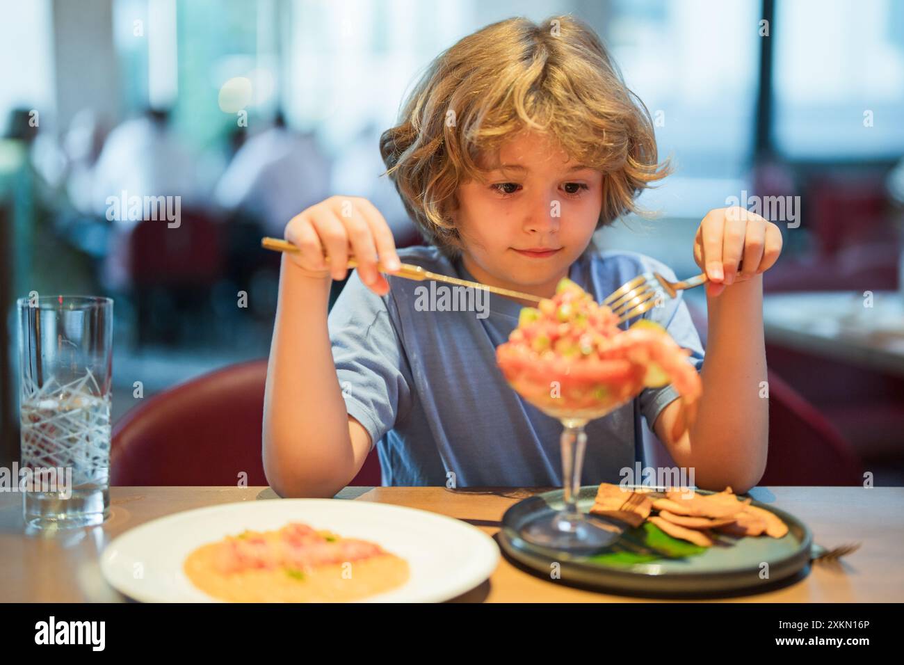 Funny cute Little boy eating seafood in cafe. Kid eat Food fish gourmet ...