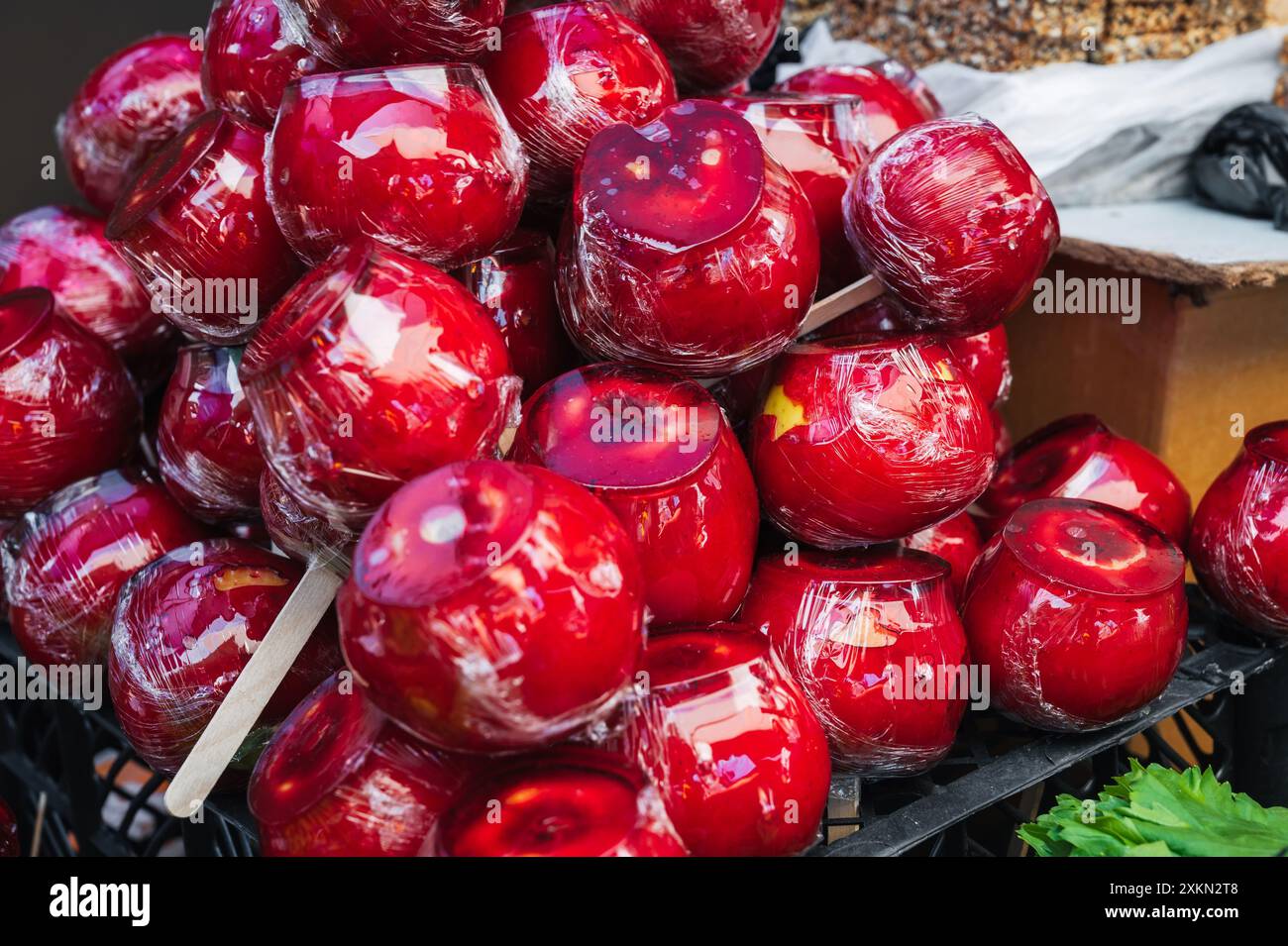 red caramel candy apples on sticks on the market counter. A traditional ...