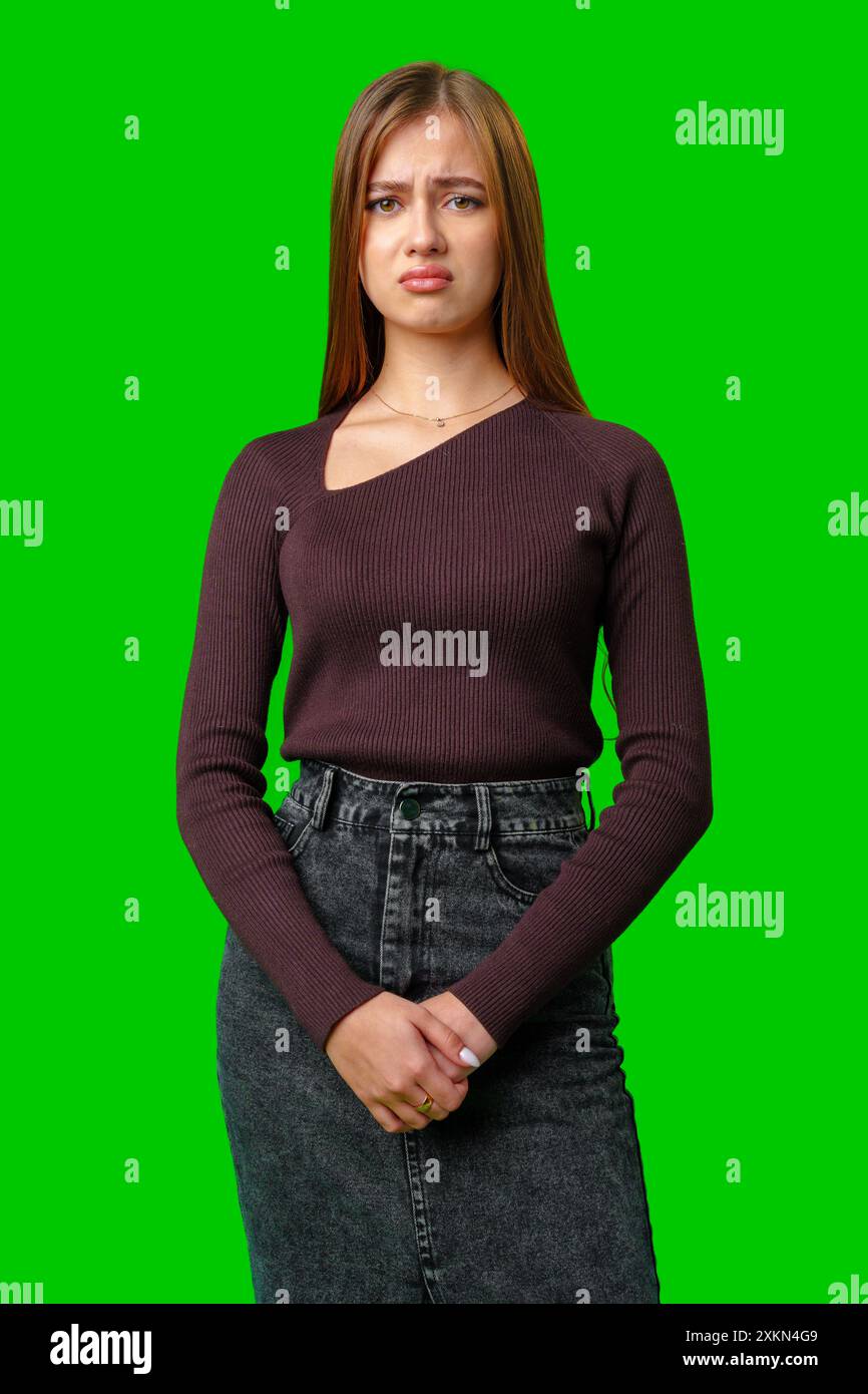 Young Woman Standing Against Green Screen With Frowning Expression ...