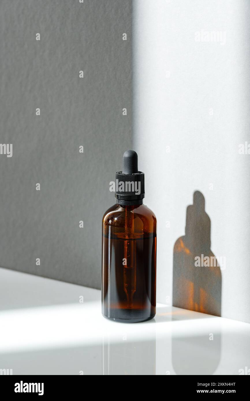 Amber Glass Dropper Bottle With Sunlight Shadow on White Surface Stock ...