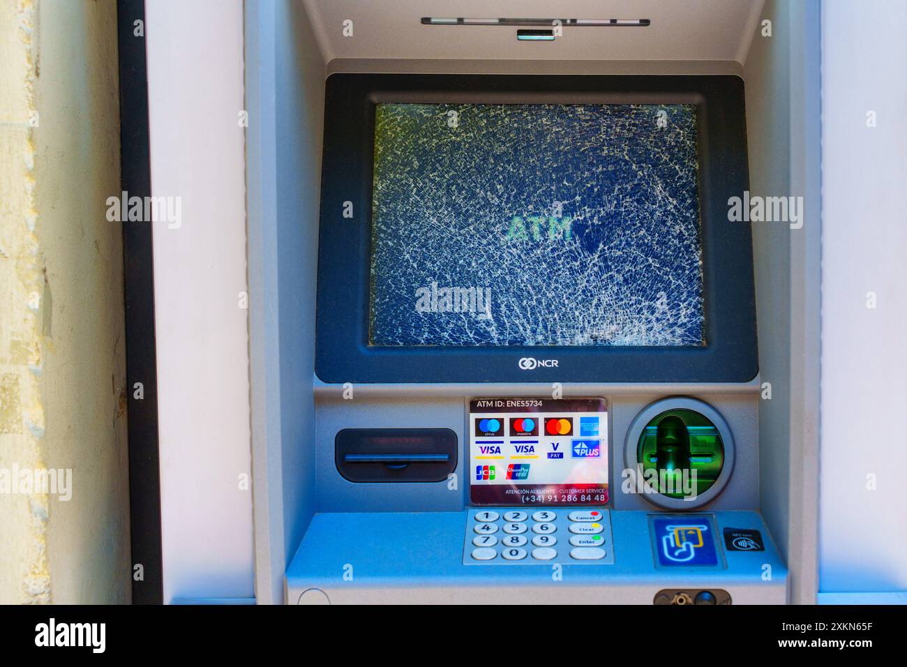 Barcelona, Spain - July 16, 2024: Cracked ATM screen showing faded ATM ...